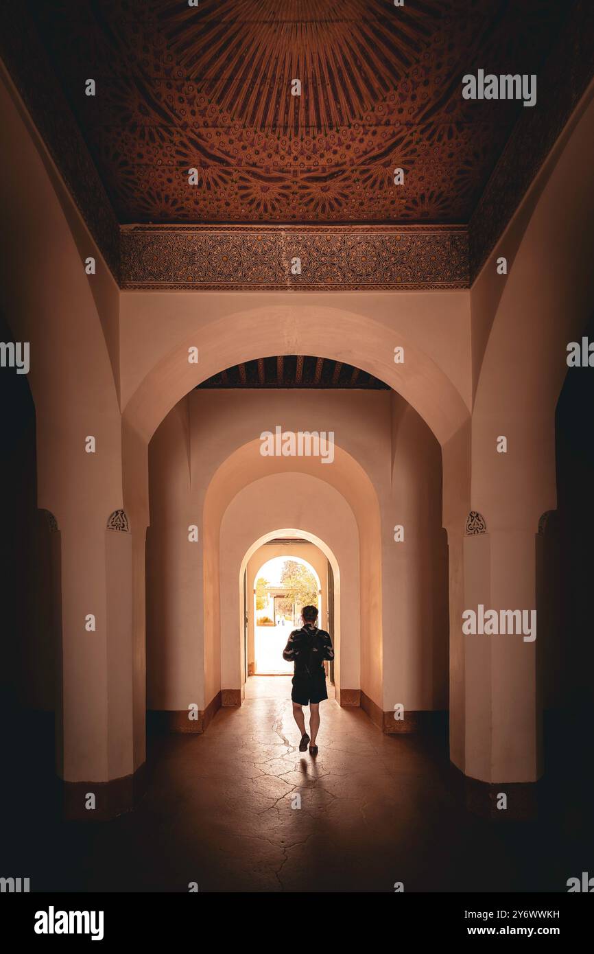 Silhouette of one man walking through an archway entrance inside the ...
