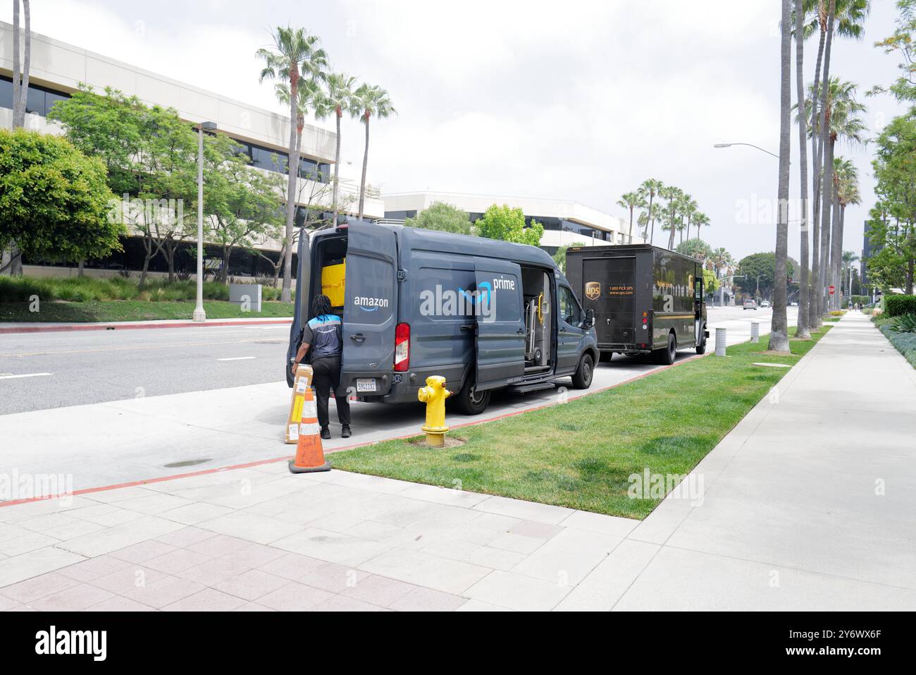 An Amazon Prime van and a UPS truck are parked on a city street ...
