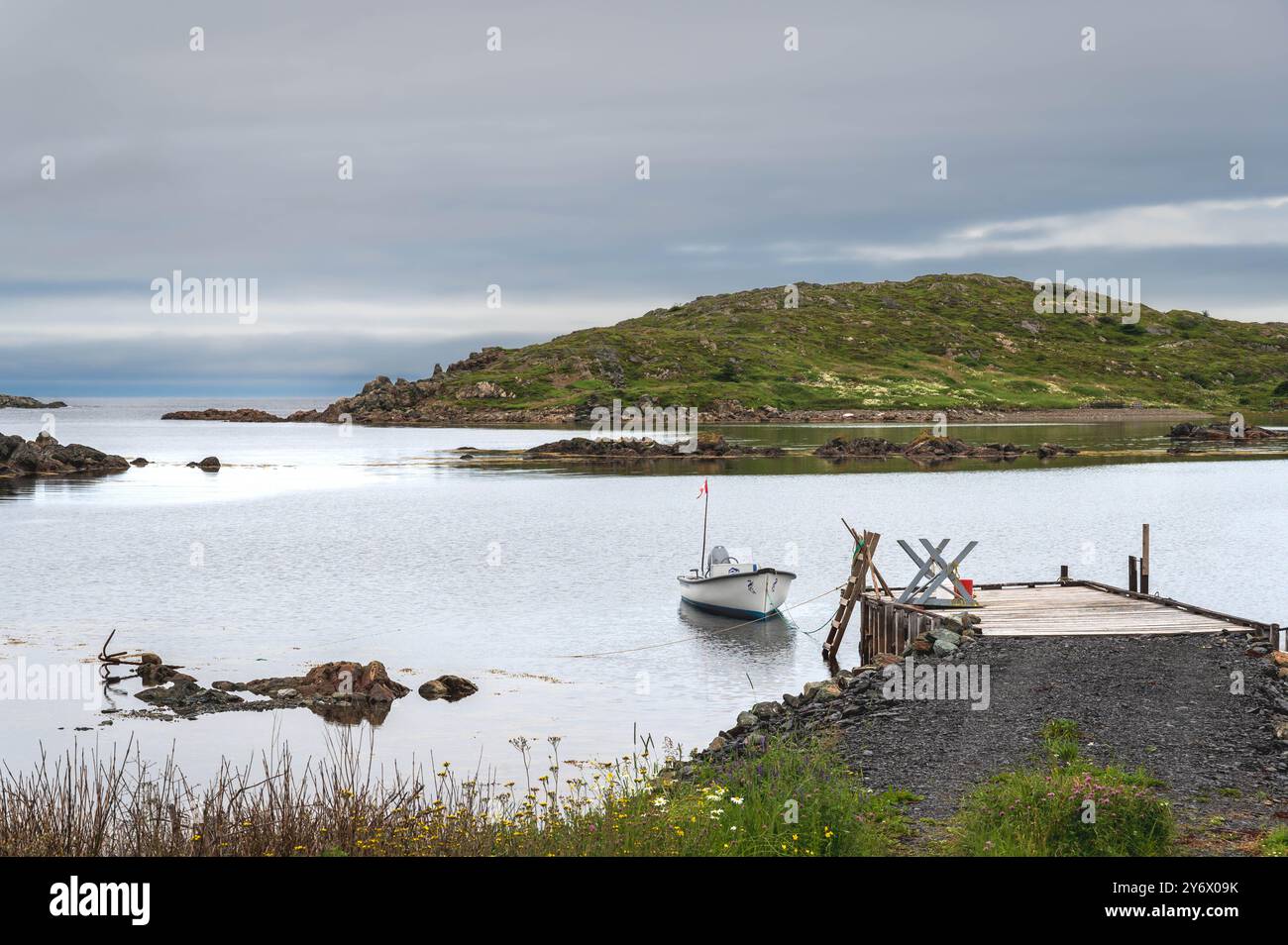 white small boat tied to wharf in sheltered harbour Stock Photo - Alamy