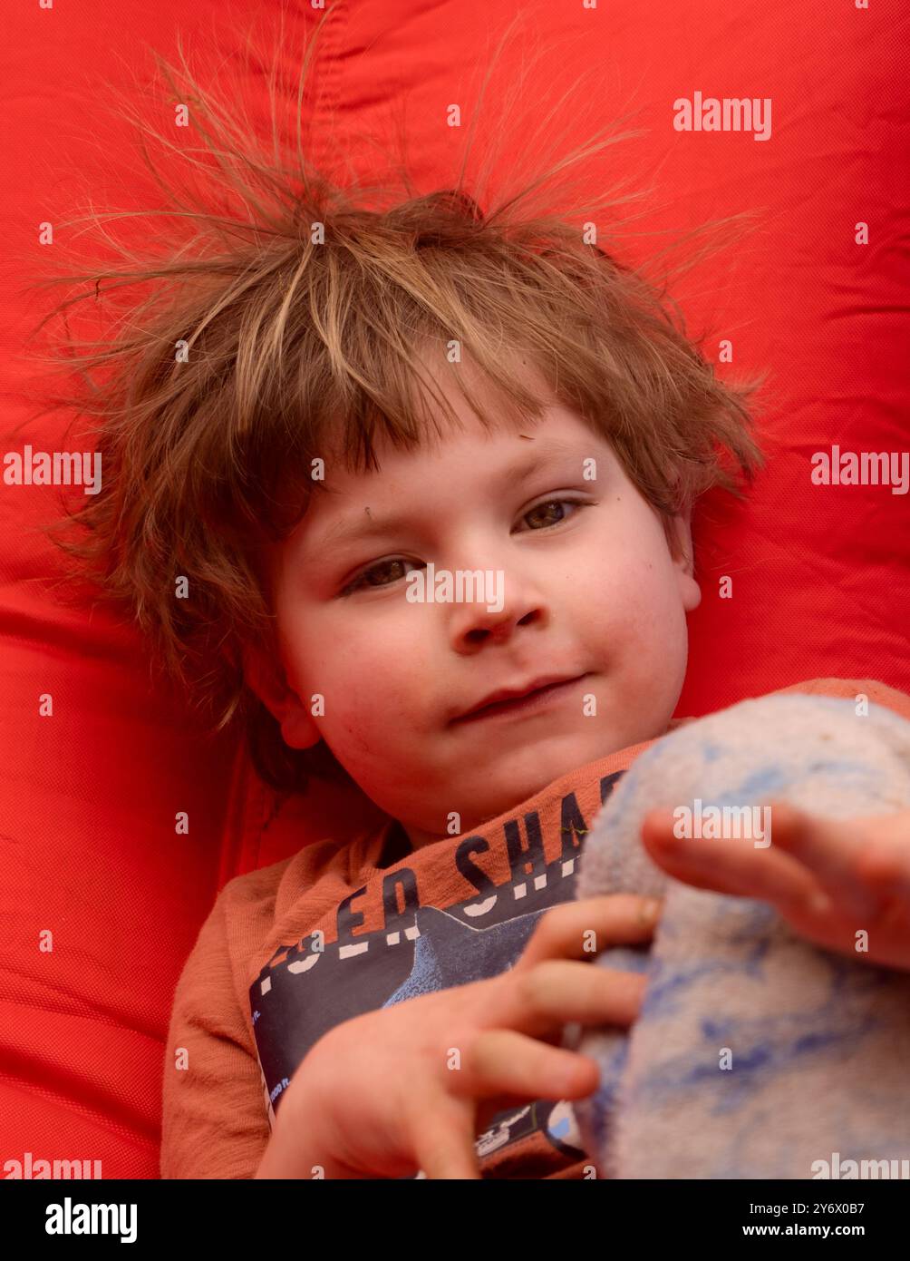 young child laying on bounce house in backyard on fall day Stock Photo ...