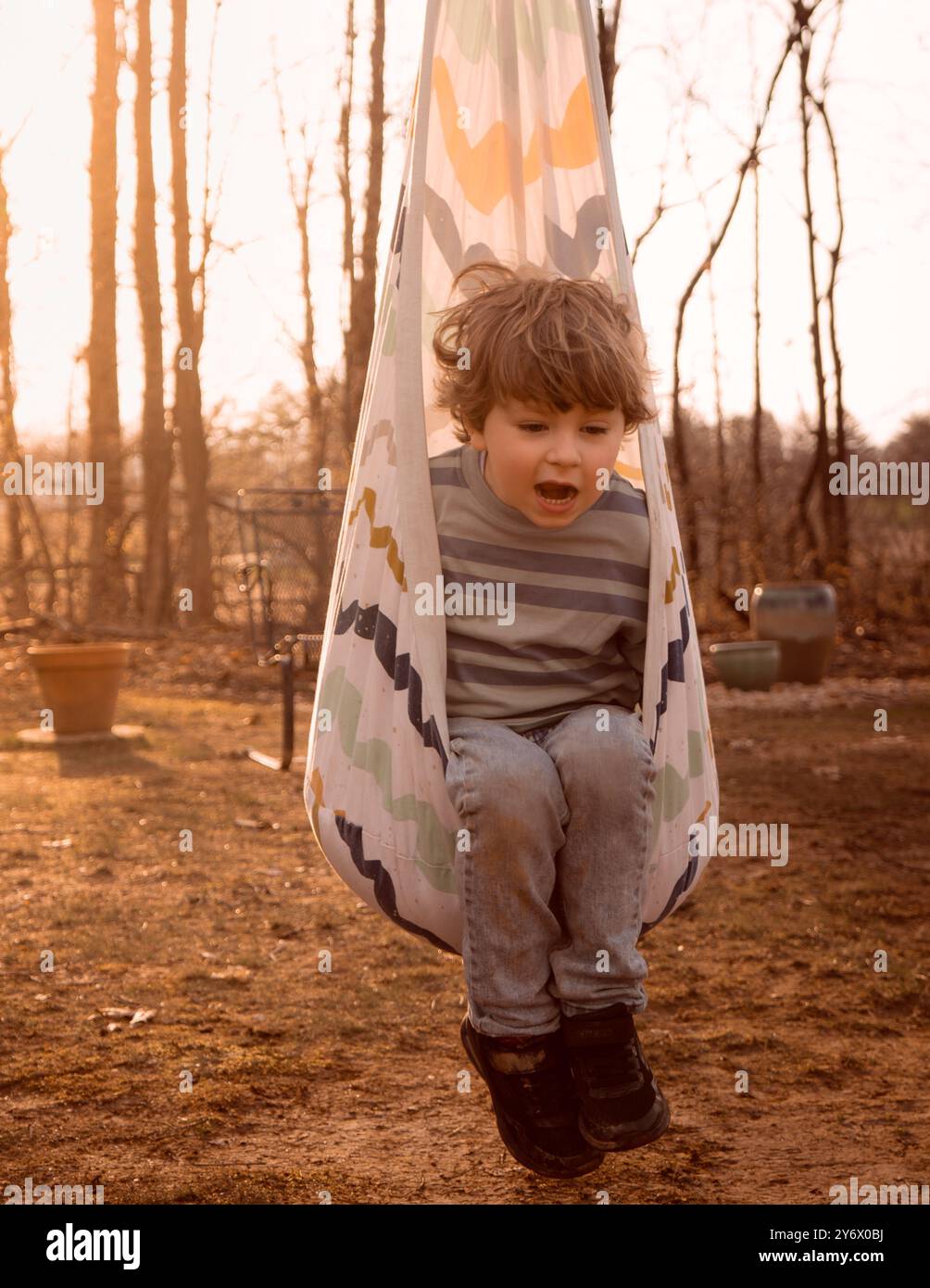 child in egg swing on playground in woods in fall Stock Photo - Alamy