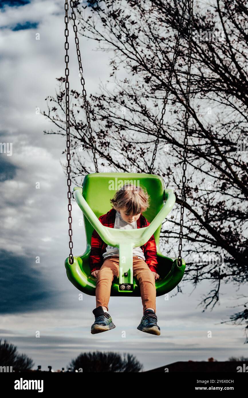 young child playing on swing outside in fall Stock Photo - Alamy
