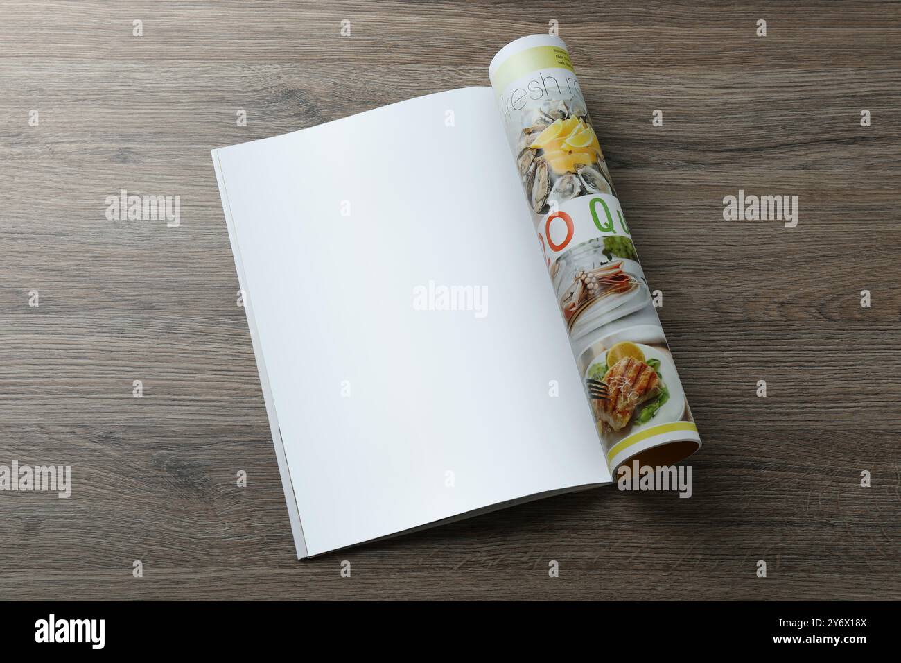 Open magazine with blank page on wooden table, top view. Mockup for ...
