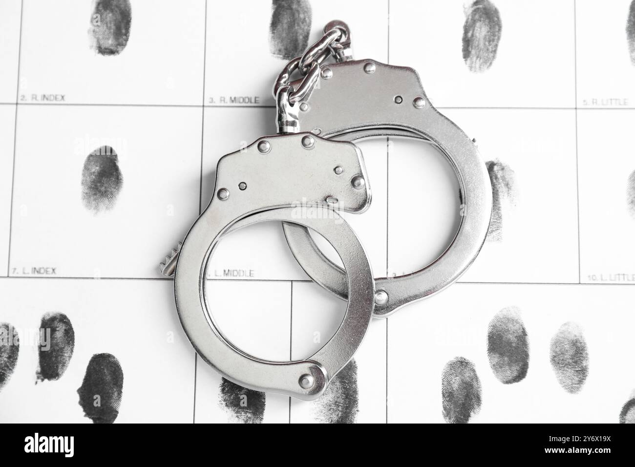 Human fingerprints and handcuffs on paper, top view. Criminal ...