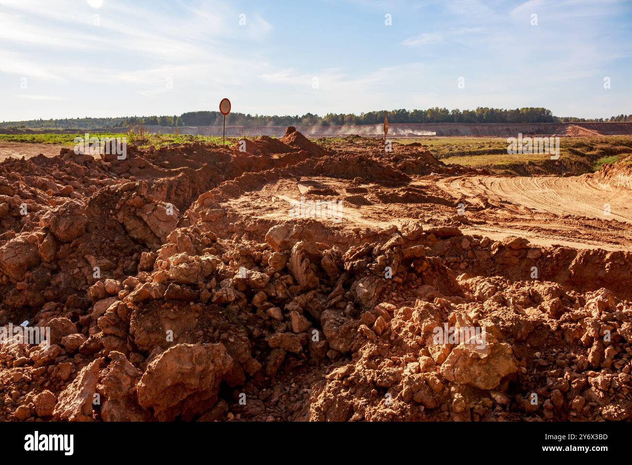 Dirt road dug up by an excavator, soil heaps Stock Photo - Alamy