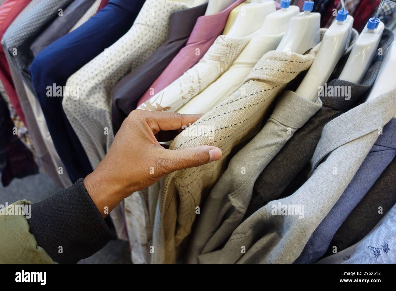 Choosing Apparel from a Clothing Rack that Features Varied Textures and ...