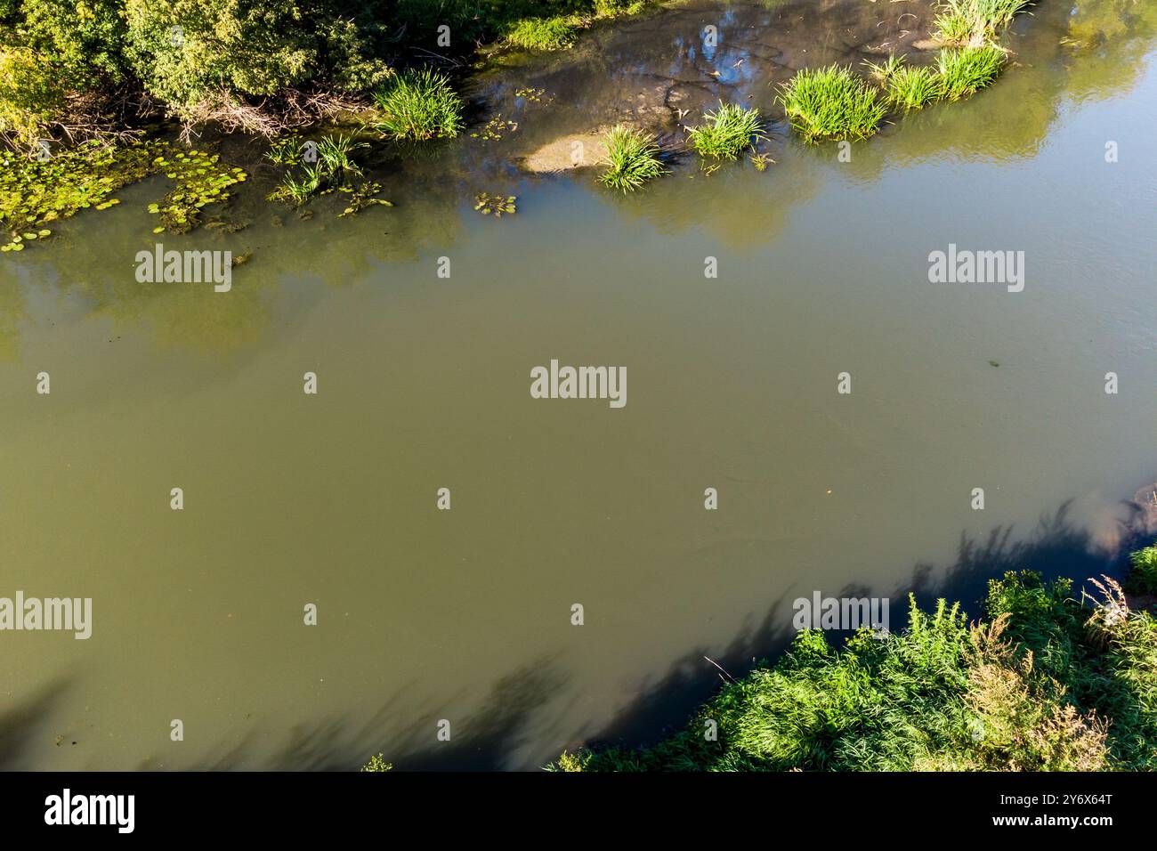 Low altitude view of a river bed with muddy water Stock Photo - Alamy