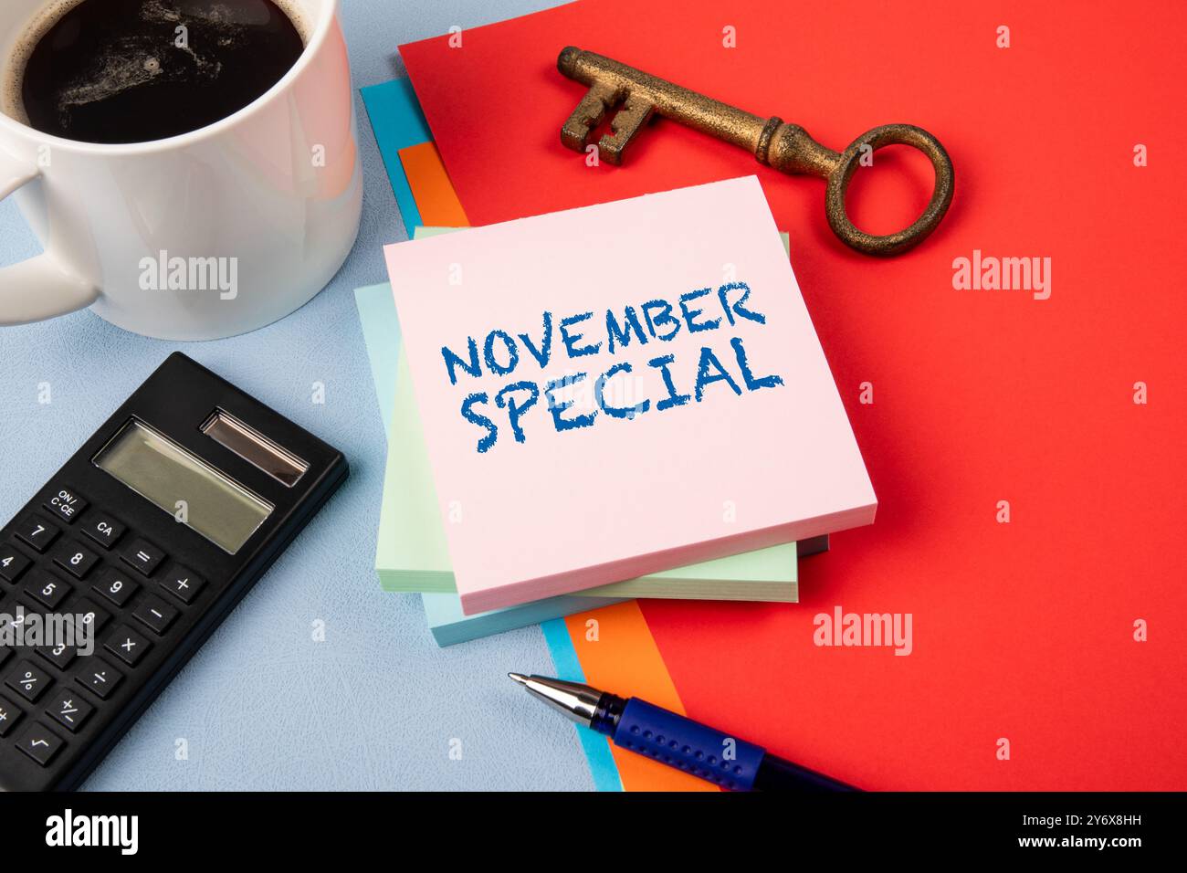 November Special. Notepad with text, coffee mug and golden key on ...