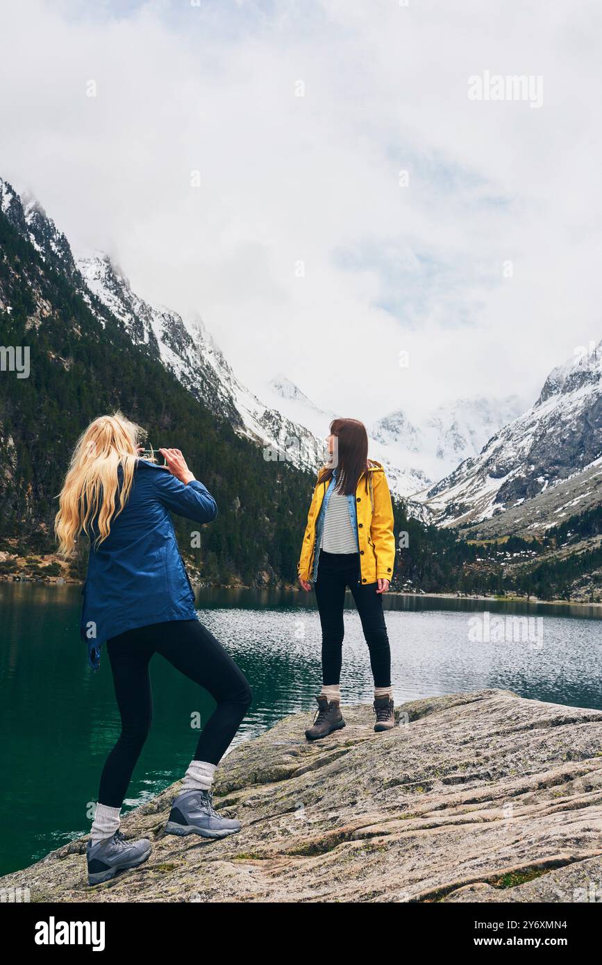 Mountain, photography and friends with smartphone, lake and women on ...