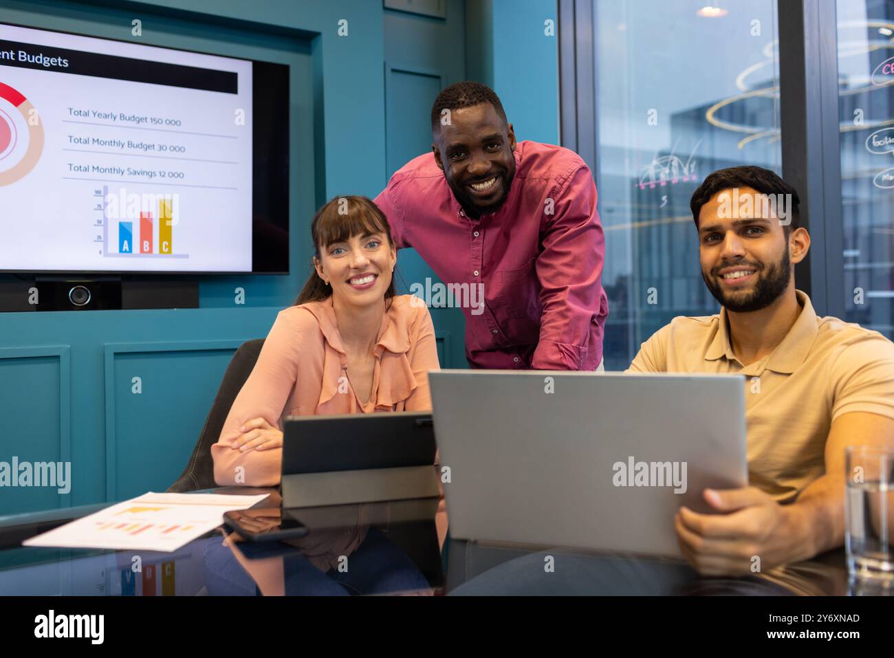 Business team collaborating on project, using laptop and tablet in ...