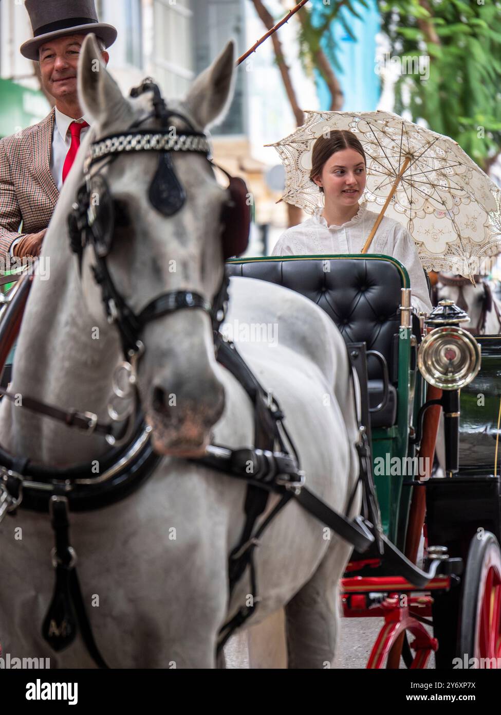 Group of people dressed in traditional Andalusian costumes, riding in a ...