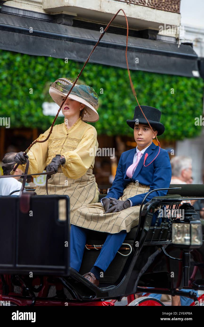 Group of people dressed in traditional Andalusian costumes, riding in a ...