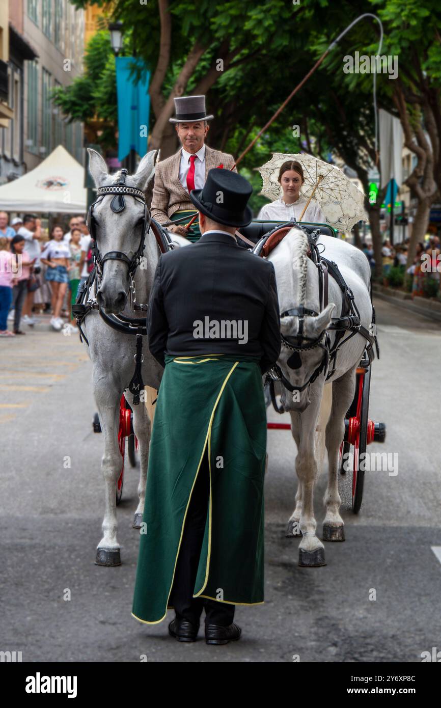 Group of people dressed in traditional Andalusian costumes, riding in a ...