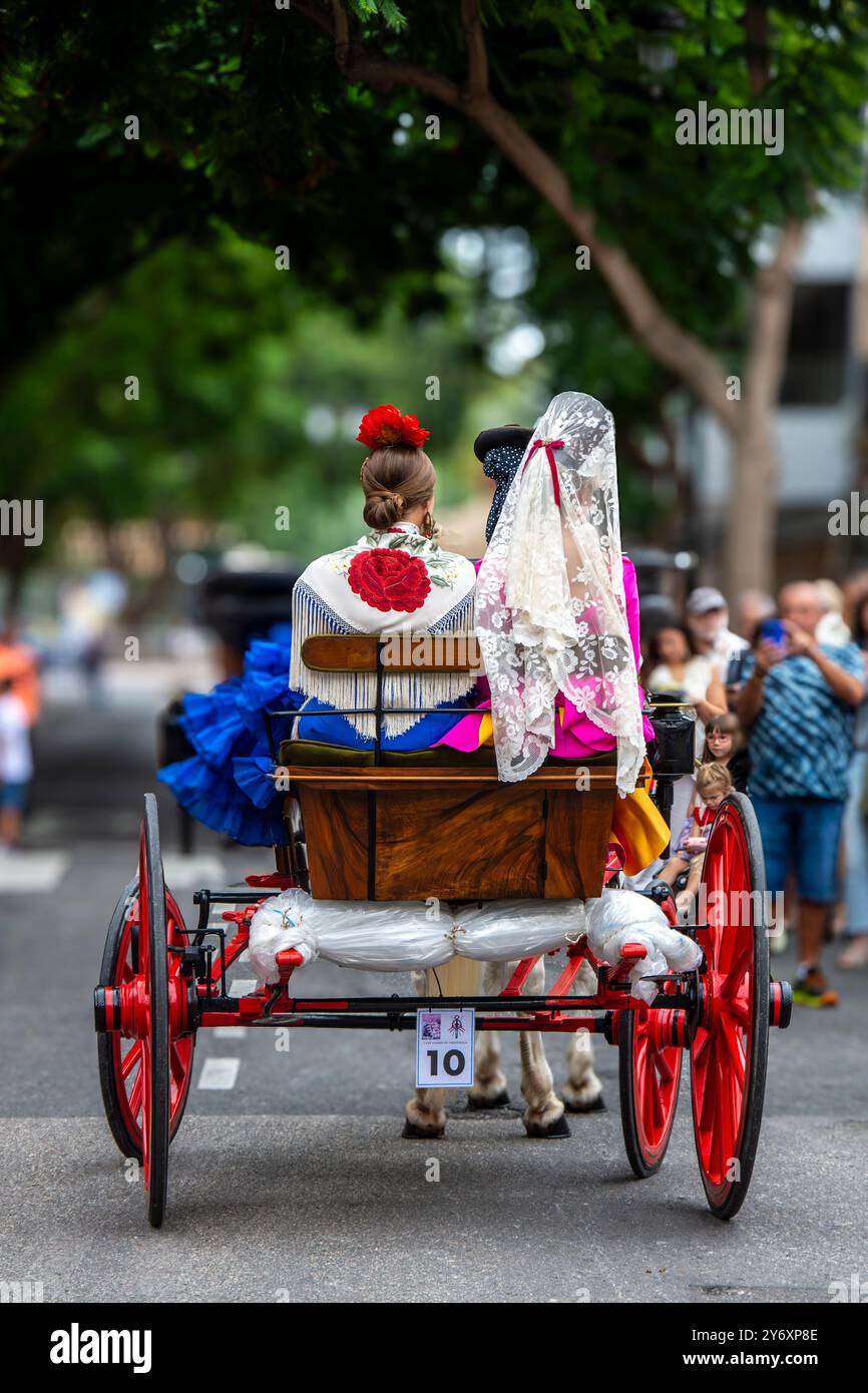 Group of people dressed in traditional Andalusian costumes, riding in a ...