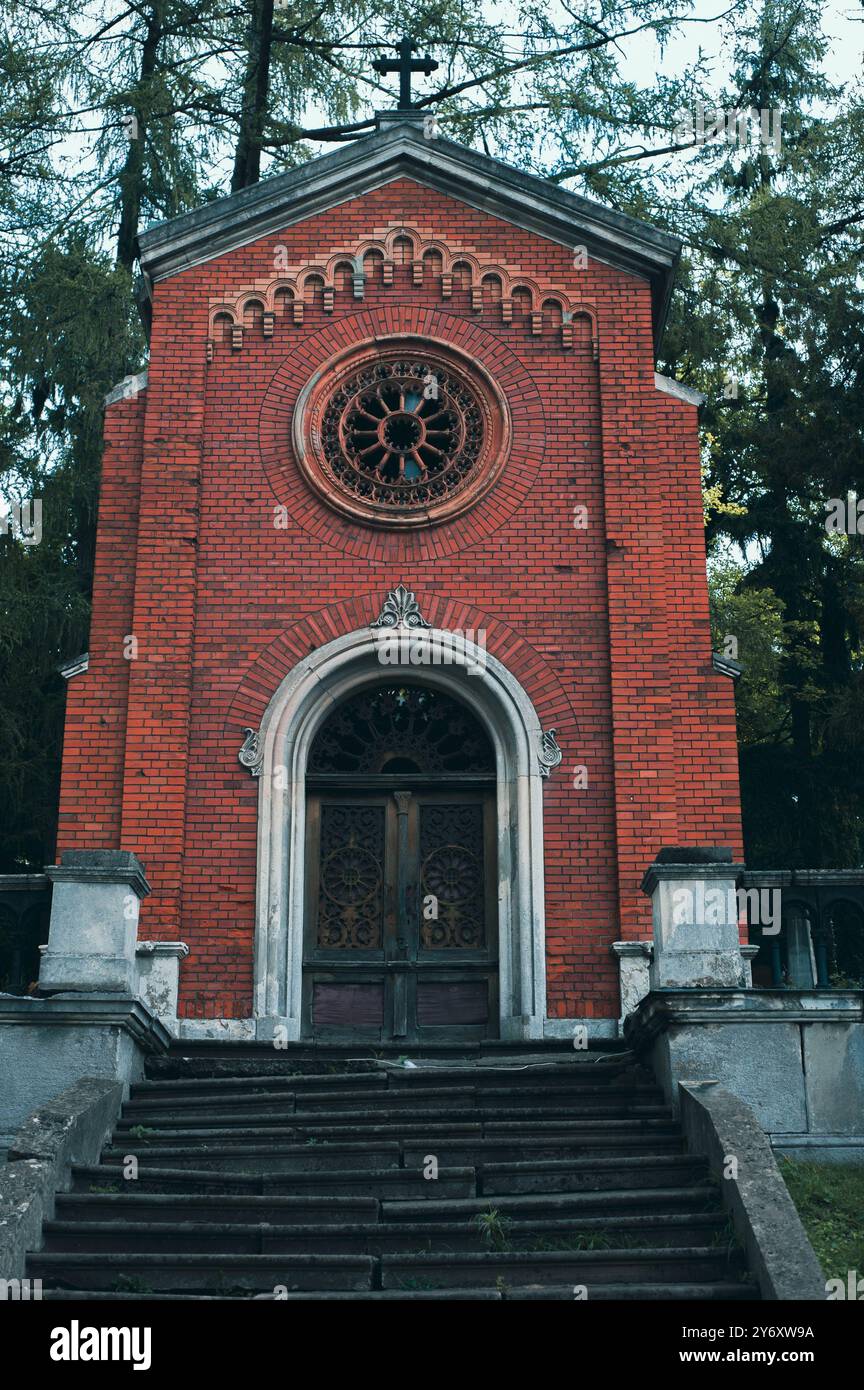 A close-up view of an old red brick chapel with ornate doors and a ...