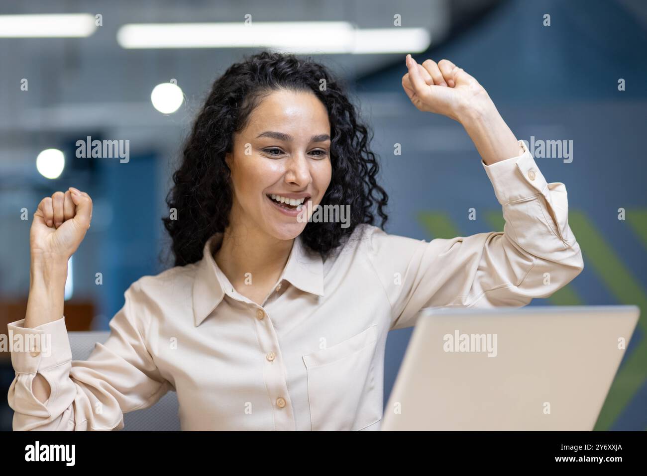 Excited office employee expressing triumph and happiness with raised ...