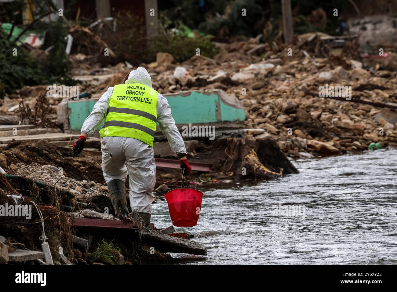 Polish army servicemen collect debris from destroyed buildings as ...