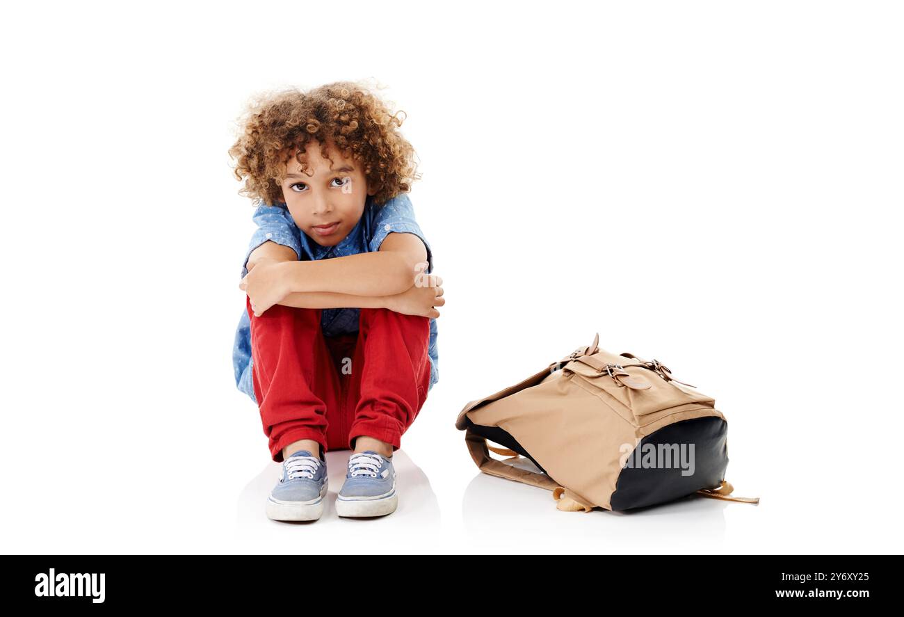 Portrait, sad and child with backpack on a white background for ...