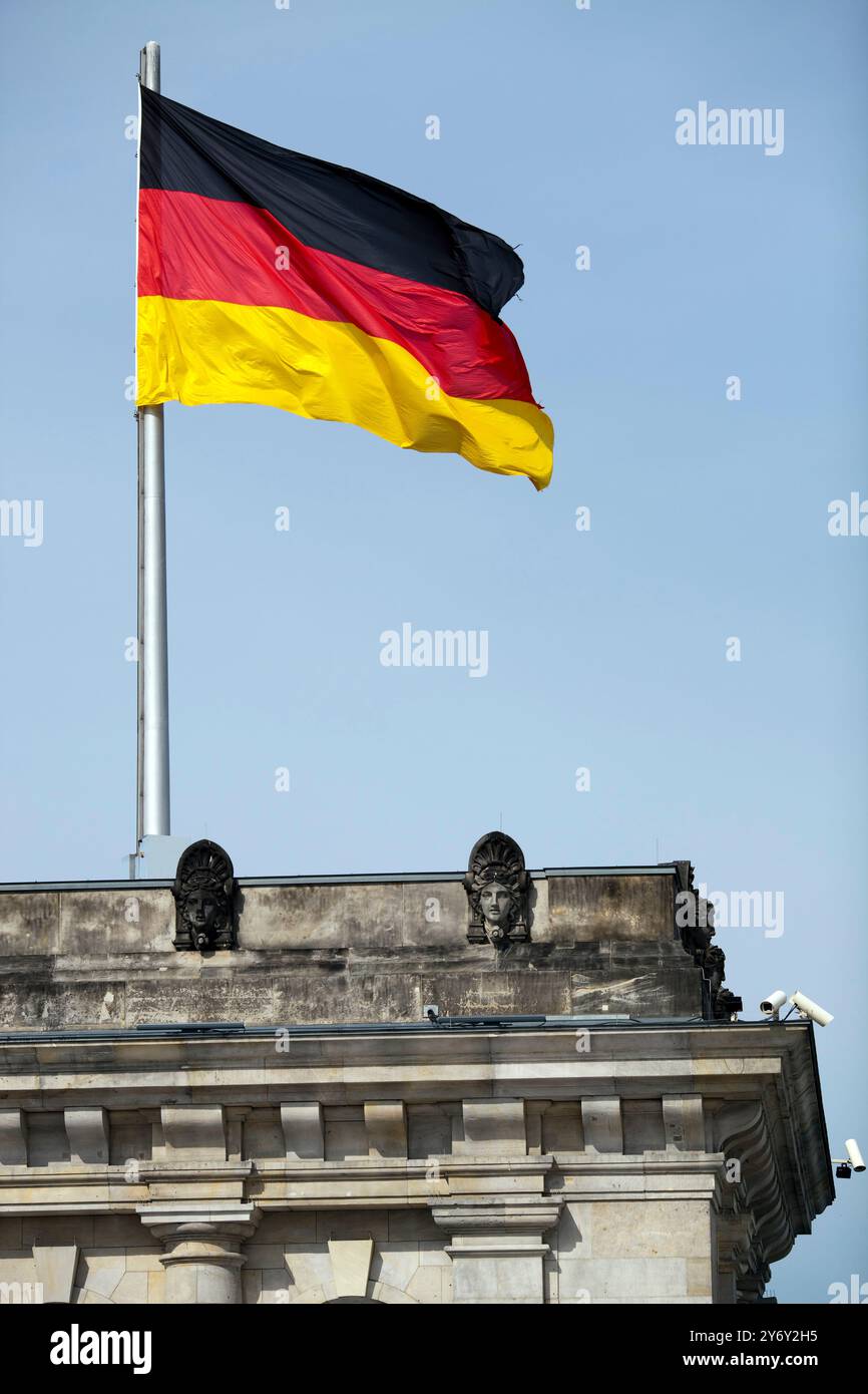 The German flag waves above the Reichstag building, a key landmark in ...
