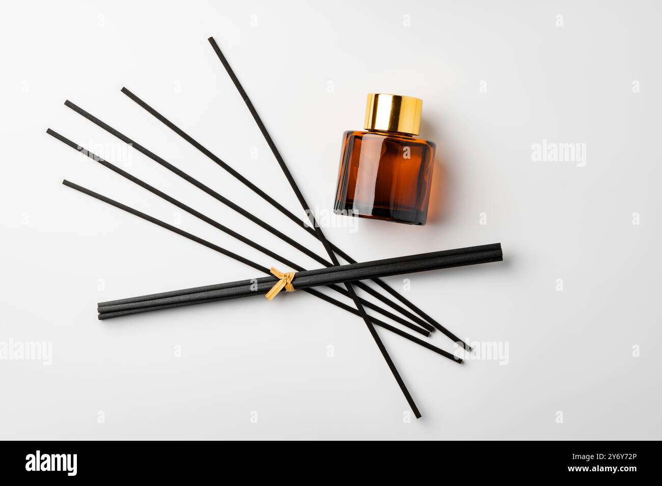 A minimalist display of essential oil and black diffuser sticks on a ...