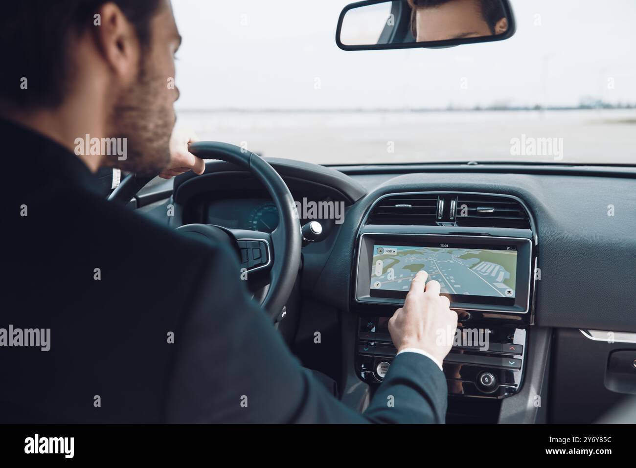 Getting around the city. Rear view of young man in full suit using ...