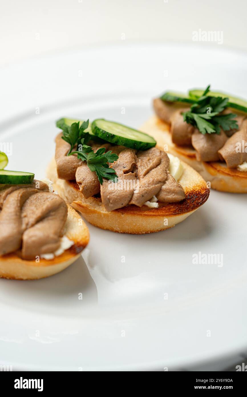 Savory canapes topped with creamy spread and cucumber slices served on ...