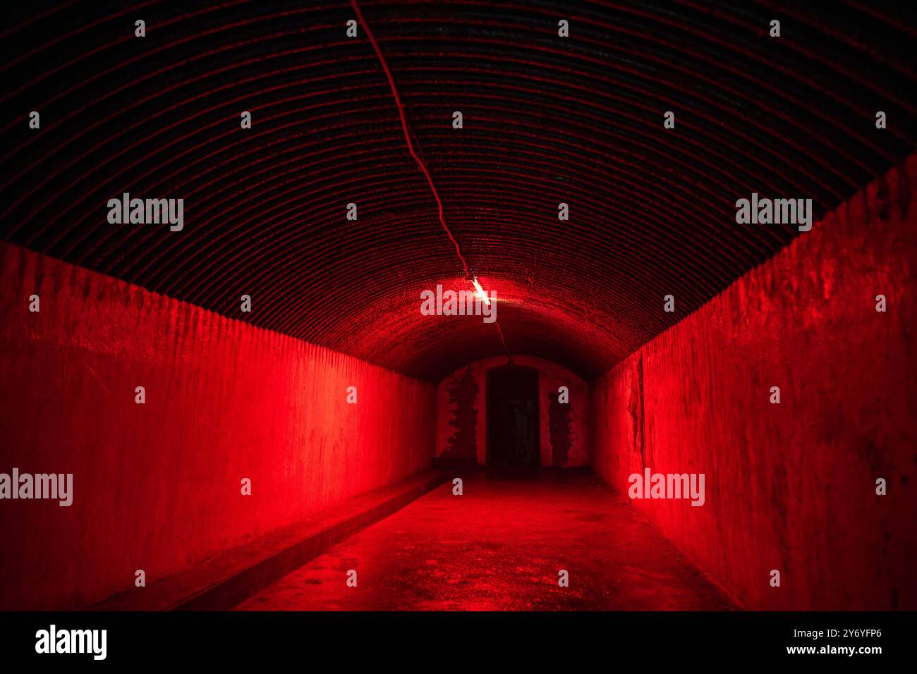Red light corridor inside underground old bunker. Tunnel illuminated ...