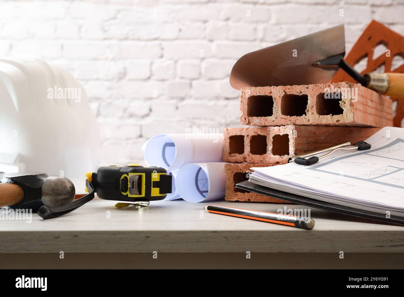 Architect's desk with plans and construction materials on white wooden ...