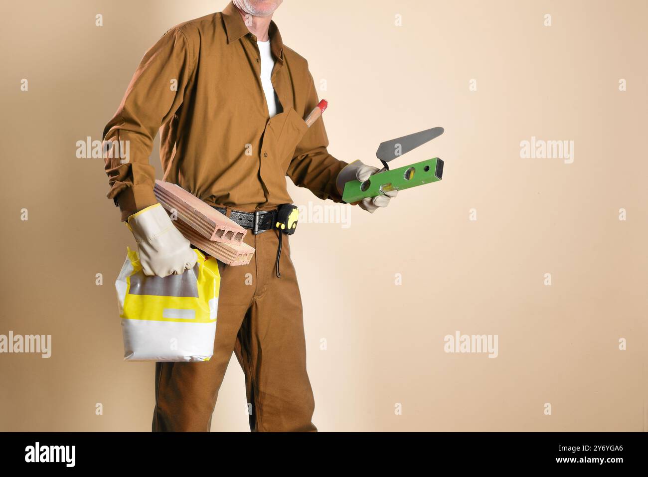 Detail of construction worker dressed in work clothes holding tools and ...