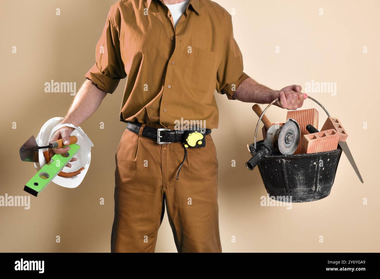 Detail of construction worker dressed in work clothes holding tools and ...