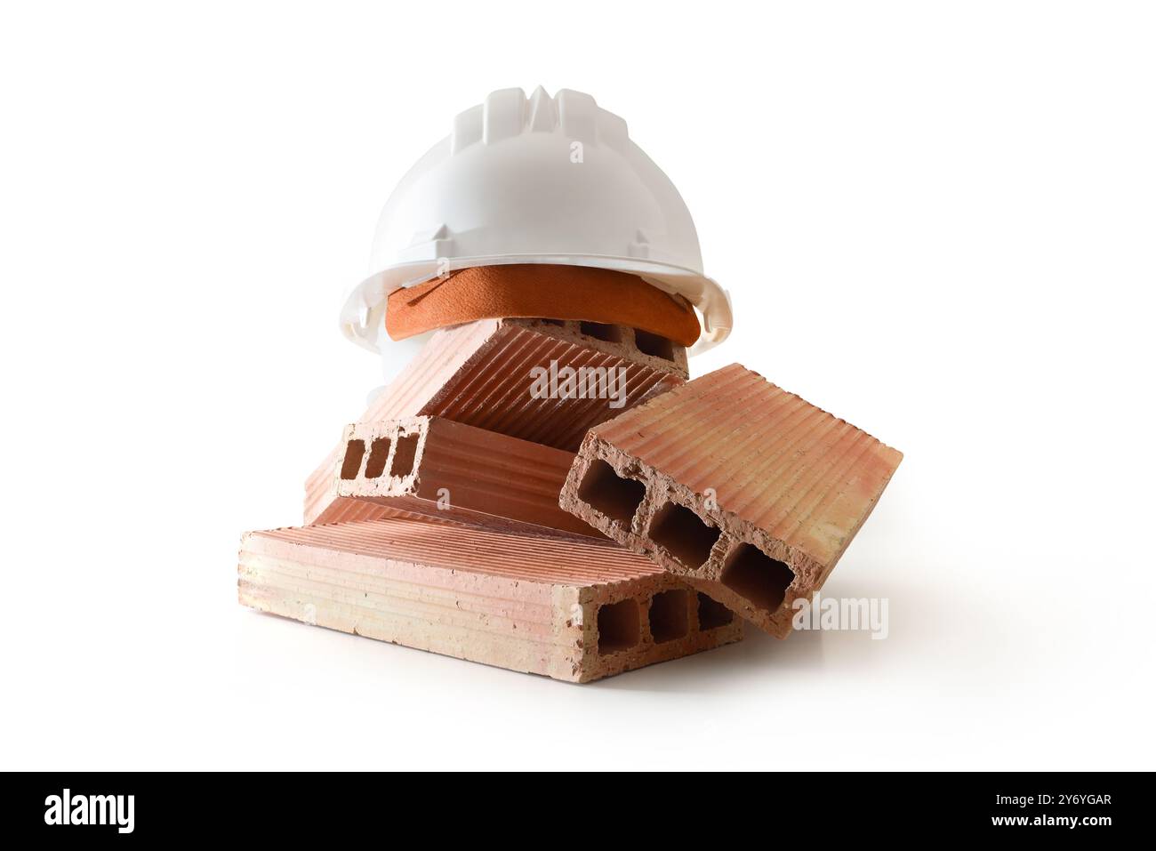 Pile of bricks and white construction helmet on top on white base ...
