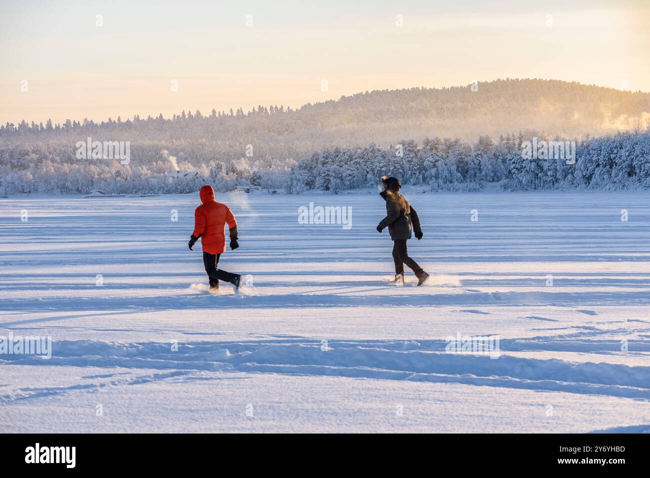 Hikers walking above the snow of the completely frozen and snow-covered ...