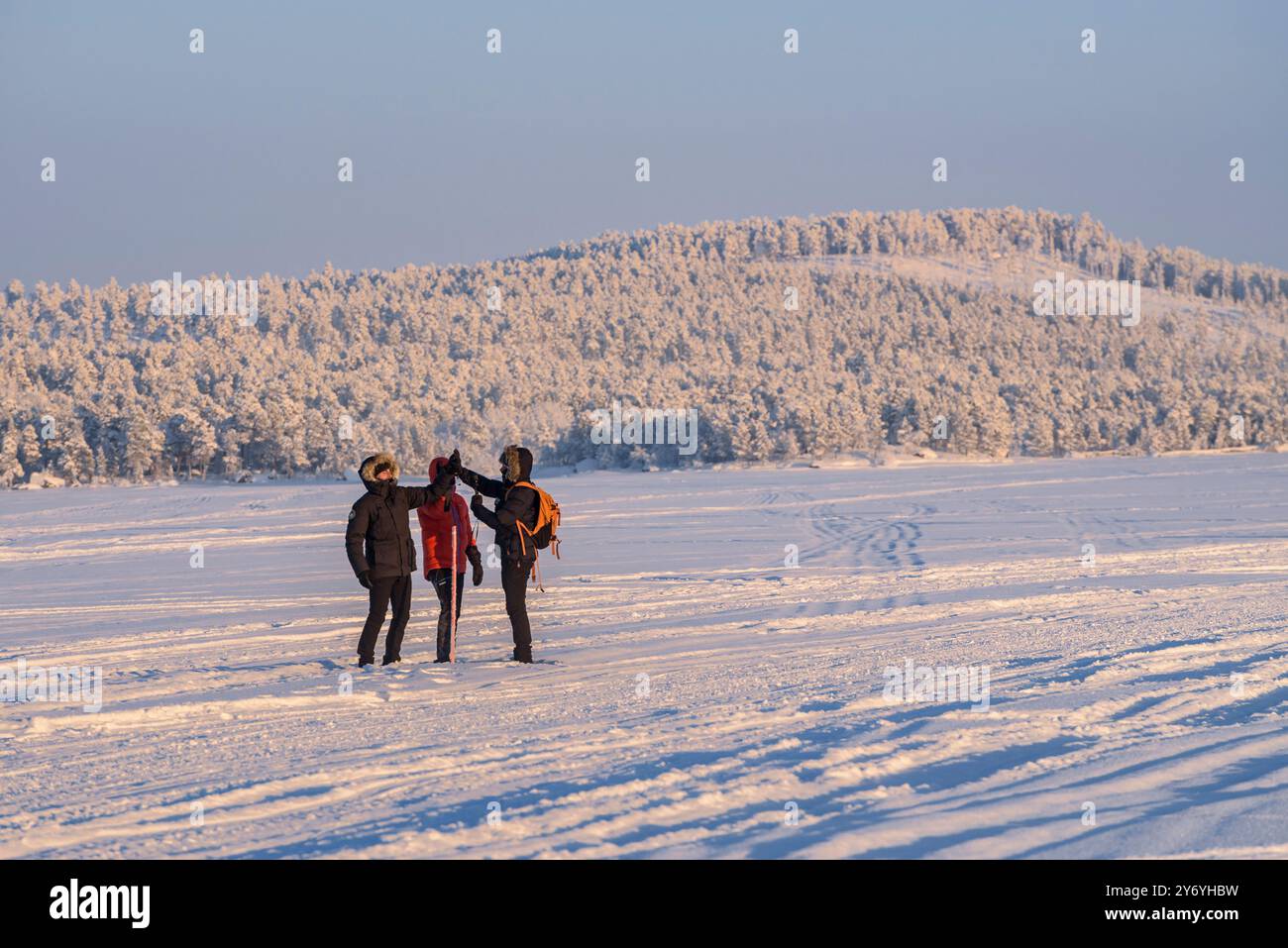 Hikers walking above the snow of the completely frozen and snow-covered ...