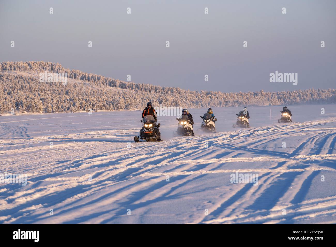 Snowmobiles passing over the frozen Lake Inari in winter, Northern ...