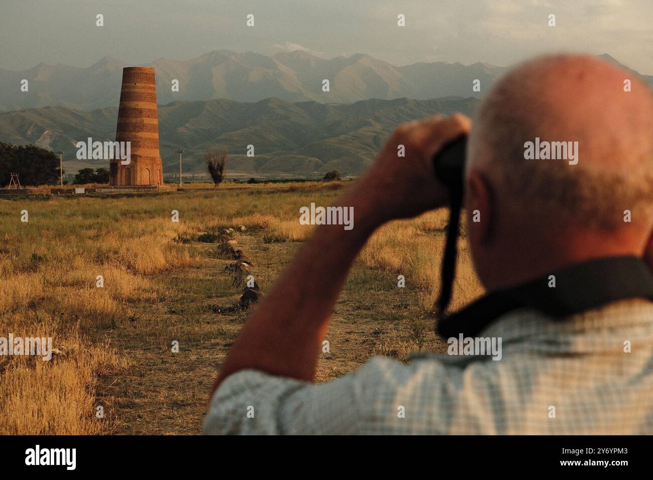 man observing mountains through binoculars, capturing nature's beauty ...