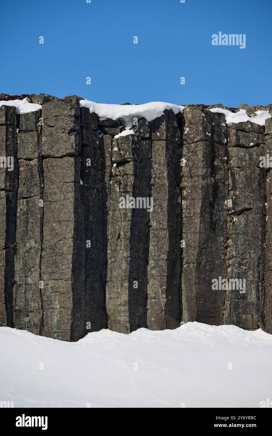 Basalt rocky formations with column cliffs covered in snow Stock Photo ...