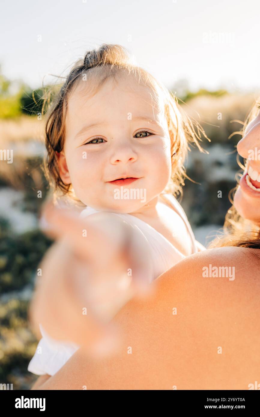 Baby in sunlight pointing toward camera Stock Photo - Alamy