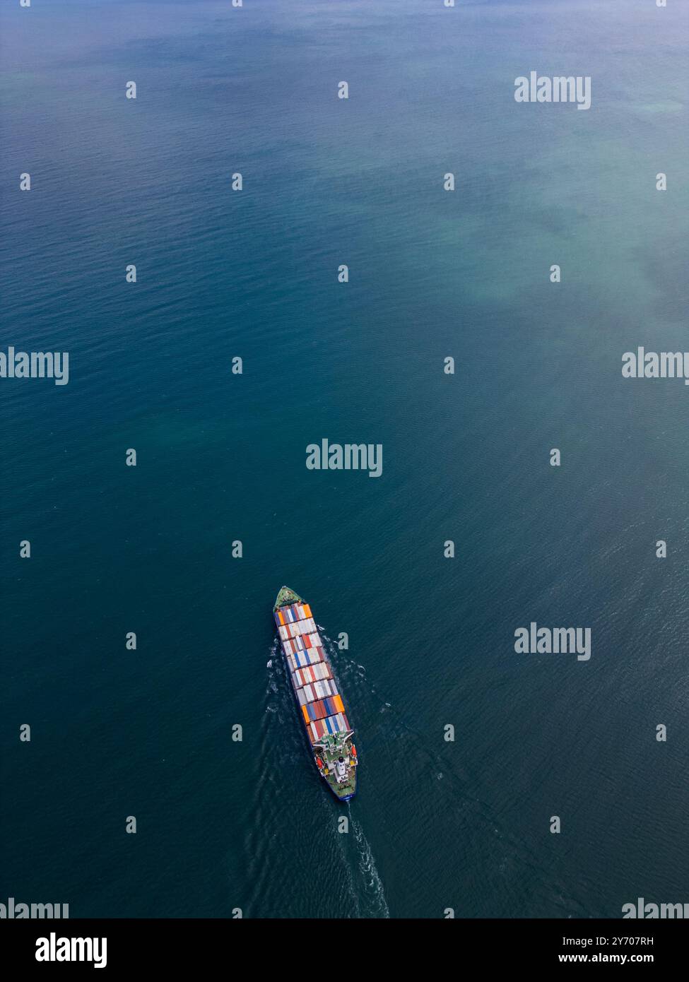 A container ship sails across the calm blue waters Stock Photo - Alamy