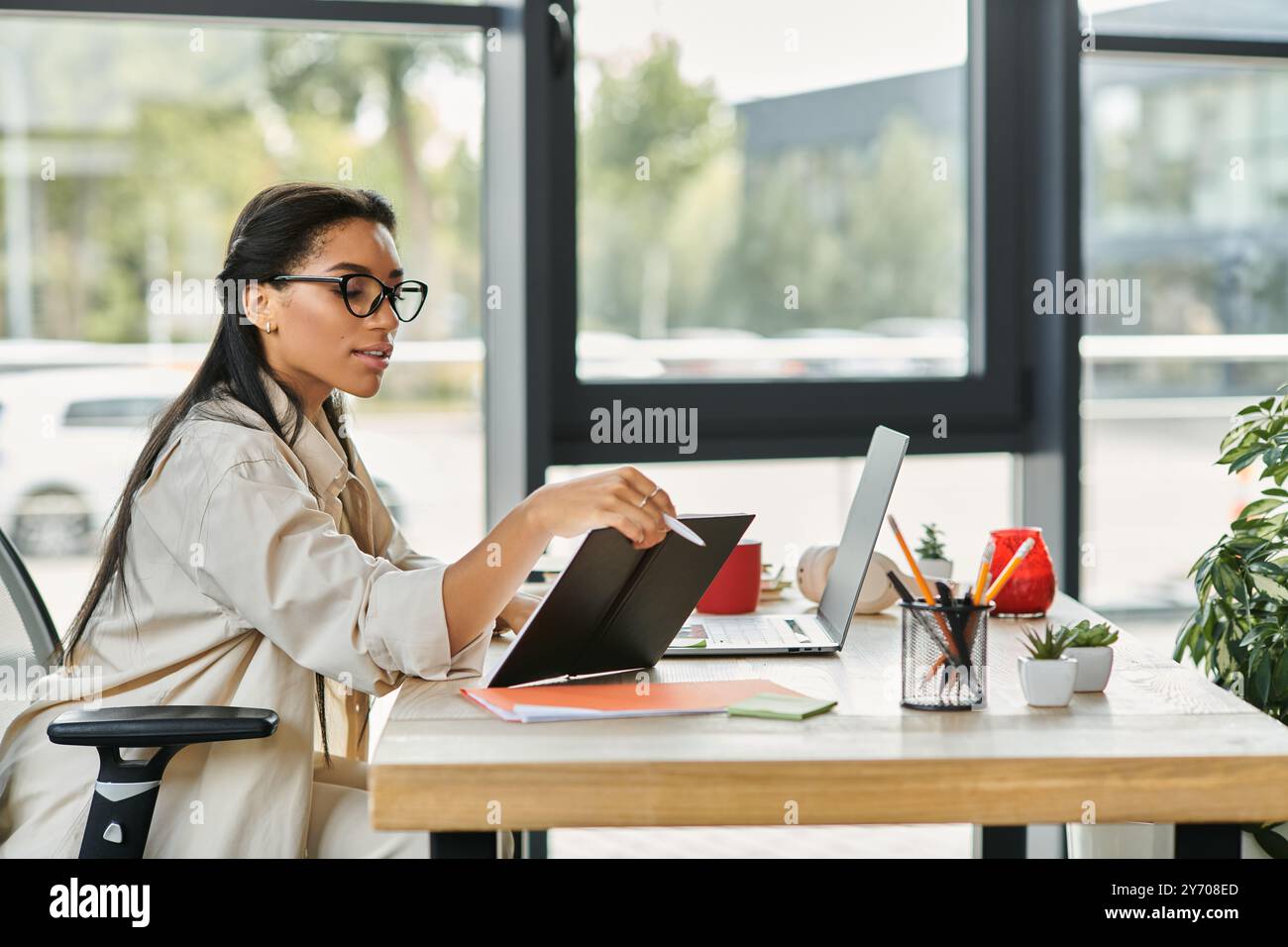 A professional woman engages with her documents while working in a ...
