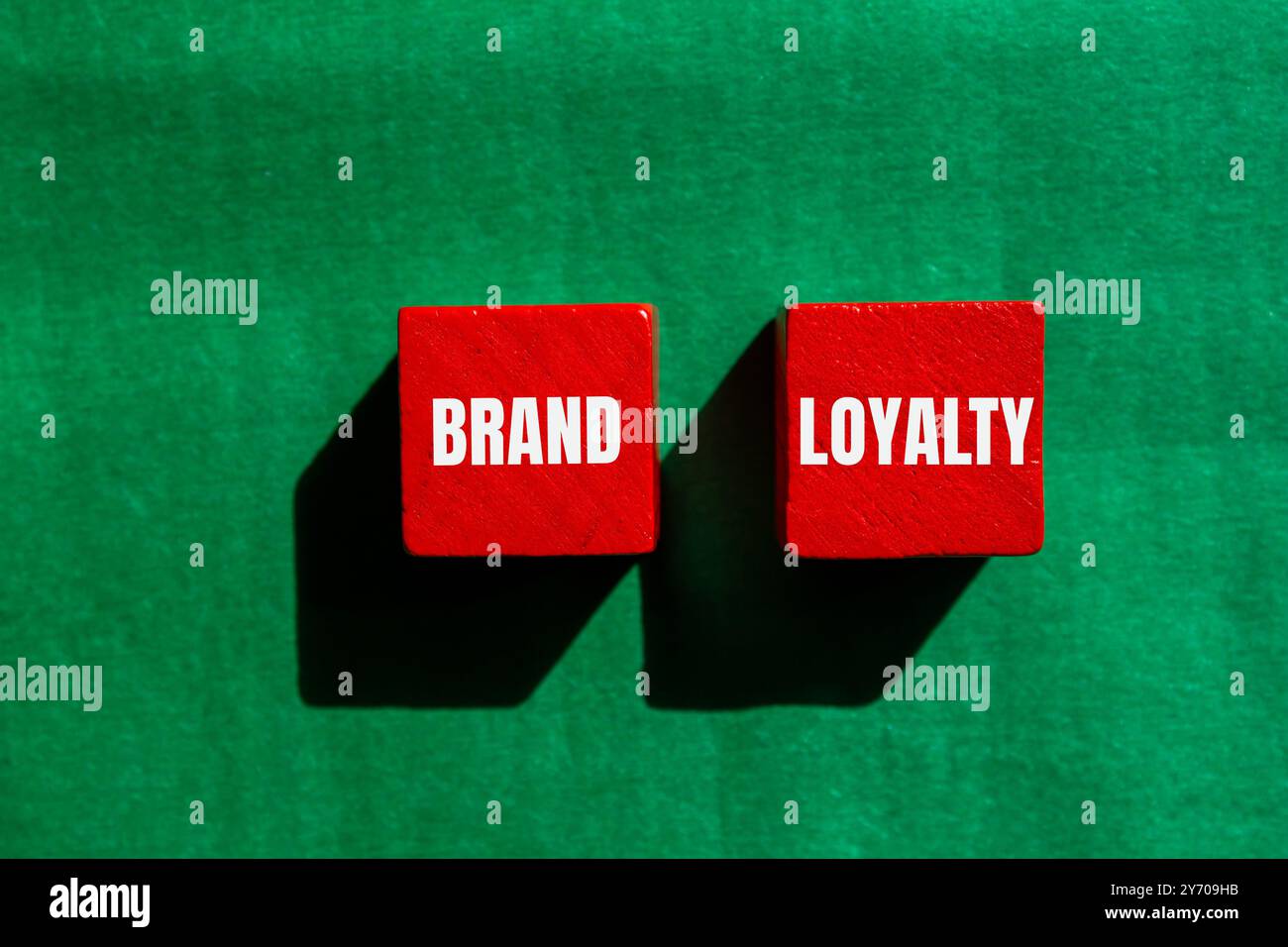 Brand loyalty message written on red wooden cubes with green background ...