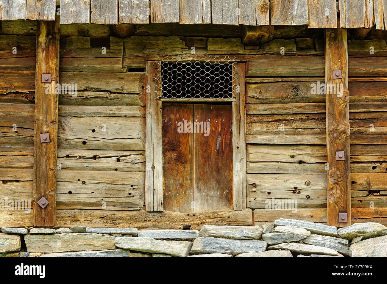 A rustic wooden building features a charming door with aged wood ...