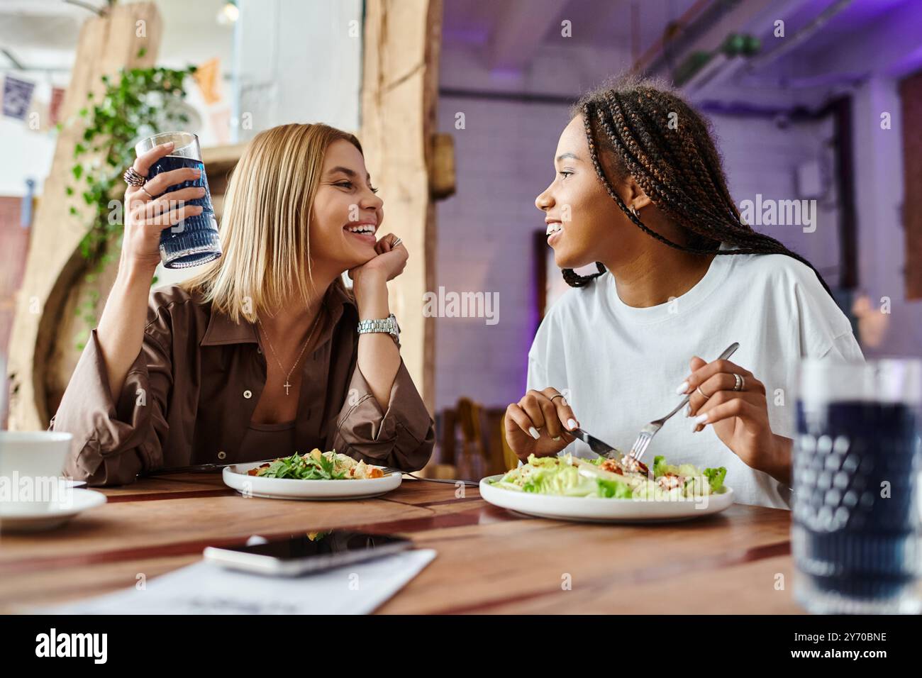 A joyful moment unfolds as a couple shares lunch at a cafe, laughing ...
