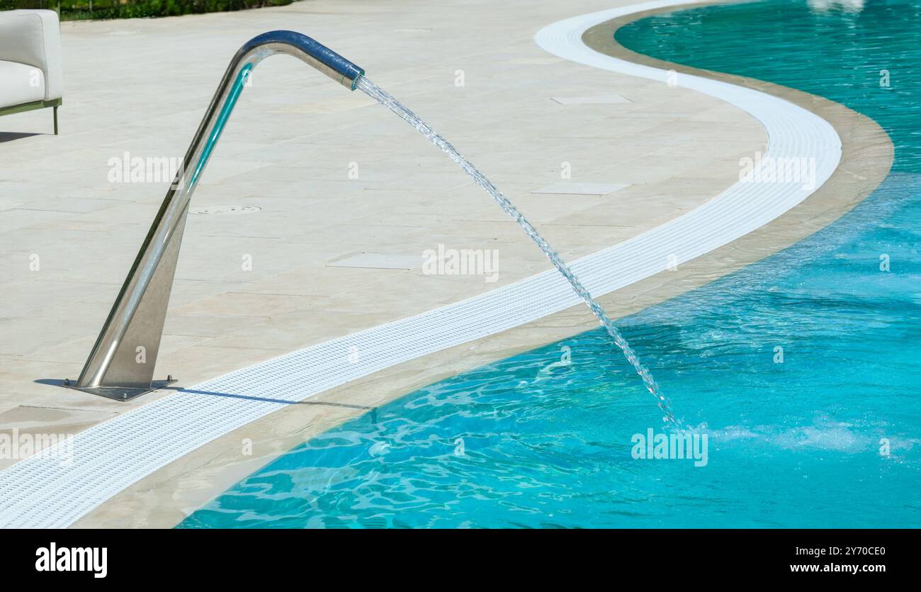 Refreshing waterfall cascades into the turquoise water of a luxury ...