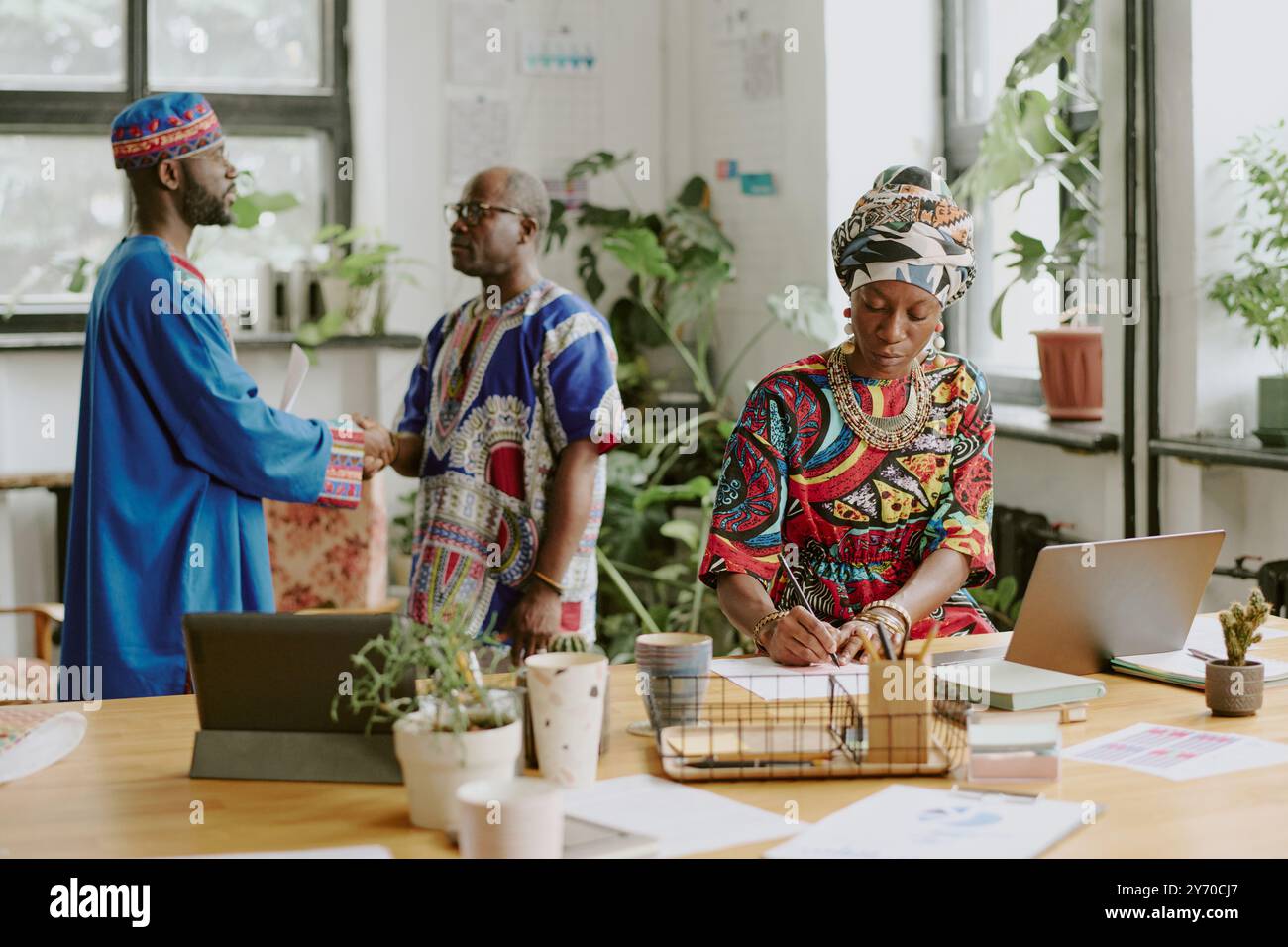 African American female worker writing documents while boss and his ...