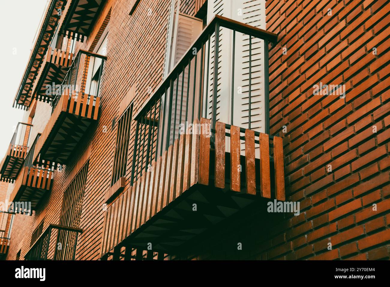 Open balcony and facade of brown brick residential house. Urban ...