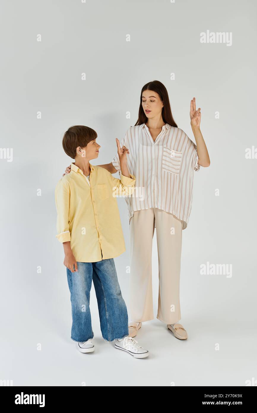 A little boy with hearing impairment engages in sign language with his ...