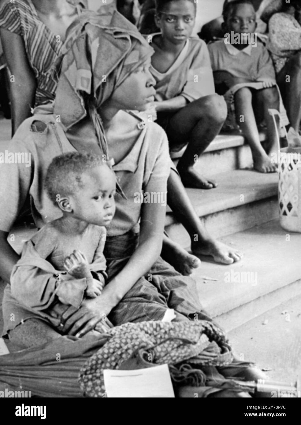 A mother sits patiently with her sick and starving baby at the Red ...