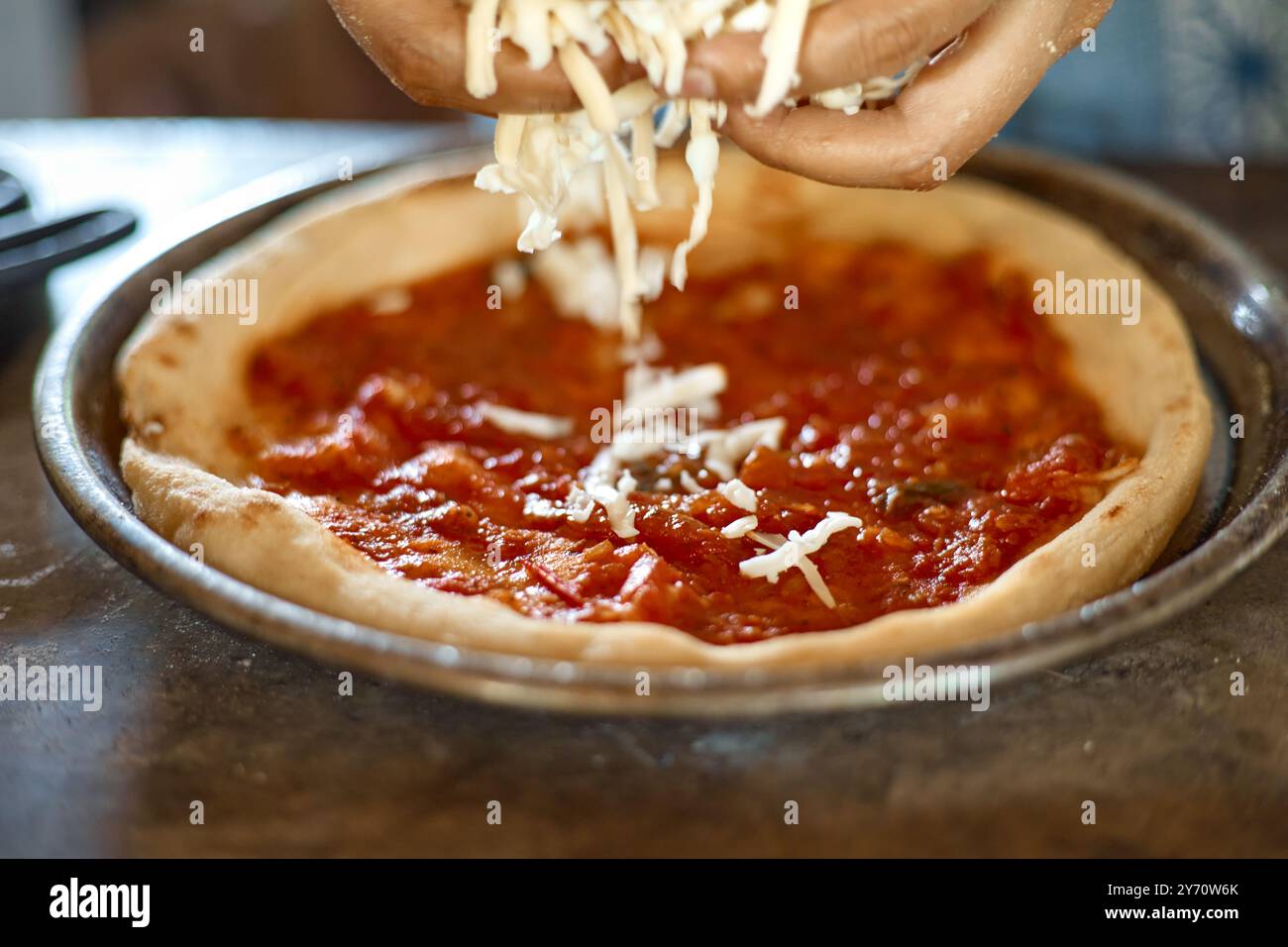 Woman's hands adding mozzarella cheese to a traditional pizza Stock ...