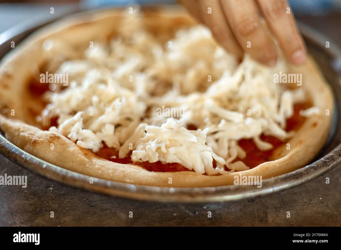 Woman's hands adding mozzarella cheese to a traditional pizza Stock ...
