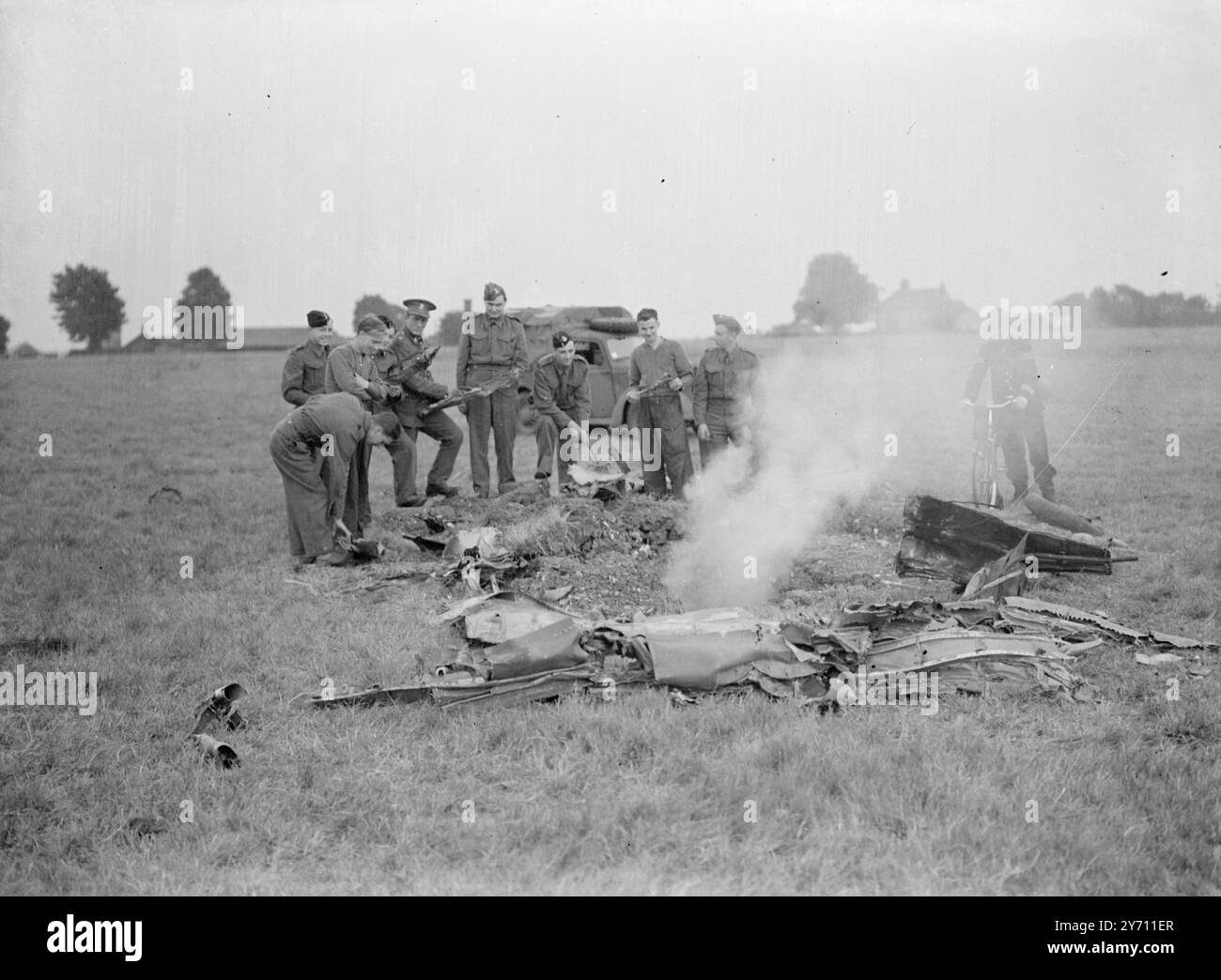 Servicemen look at the wreckage of a German fighter , the pilot , Hans ...